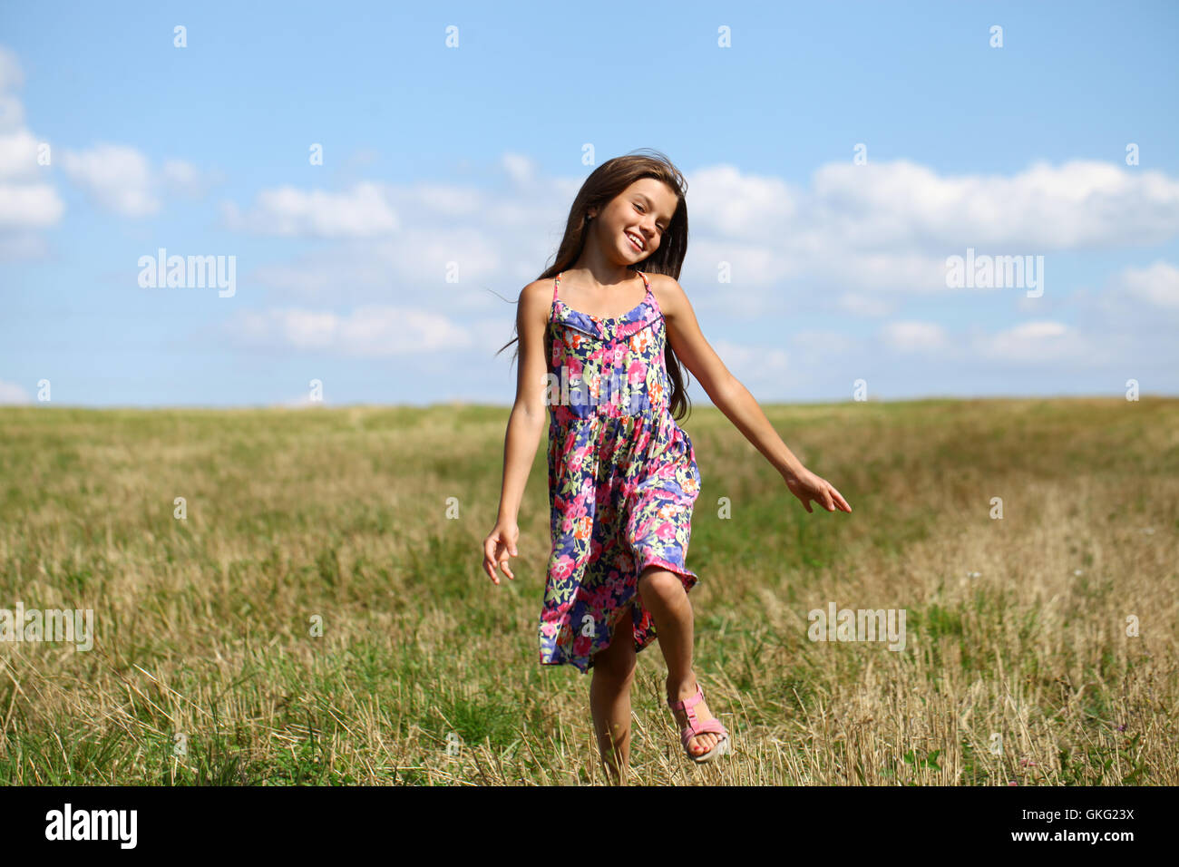 Happy little girl running in summer field Stock Photo - Alamy