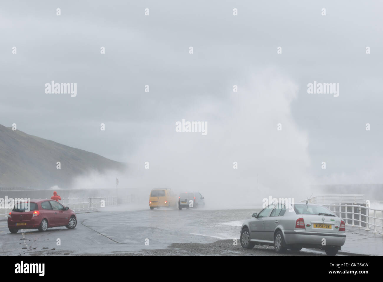 Cars parked infront of Large waves coming over the seafront along the ...