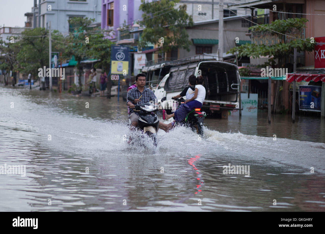 Mandalay, Myanmar. 21st Aug, 2016. Residents ride motorcycles through a ...