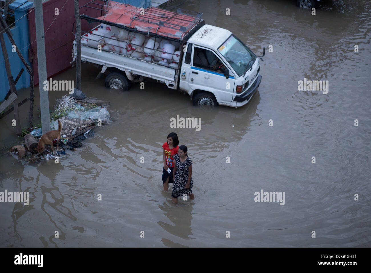 Mandalay, Myanmar. 21st Aug, 2016. Residents wade through a flooded ...