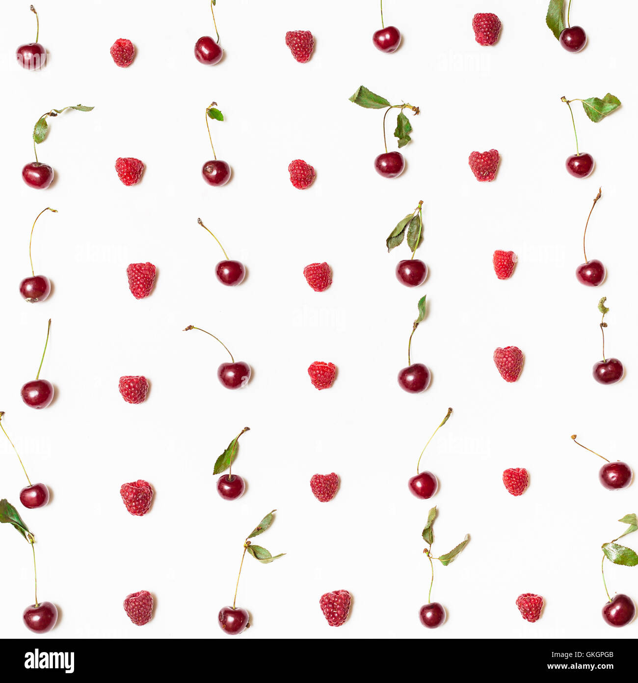many raspberries and cherries arranged on square white background Stock ...