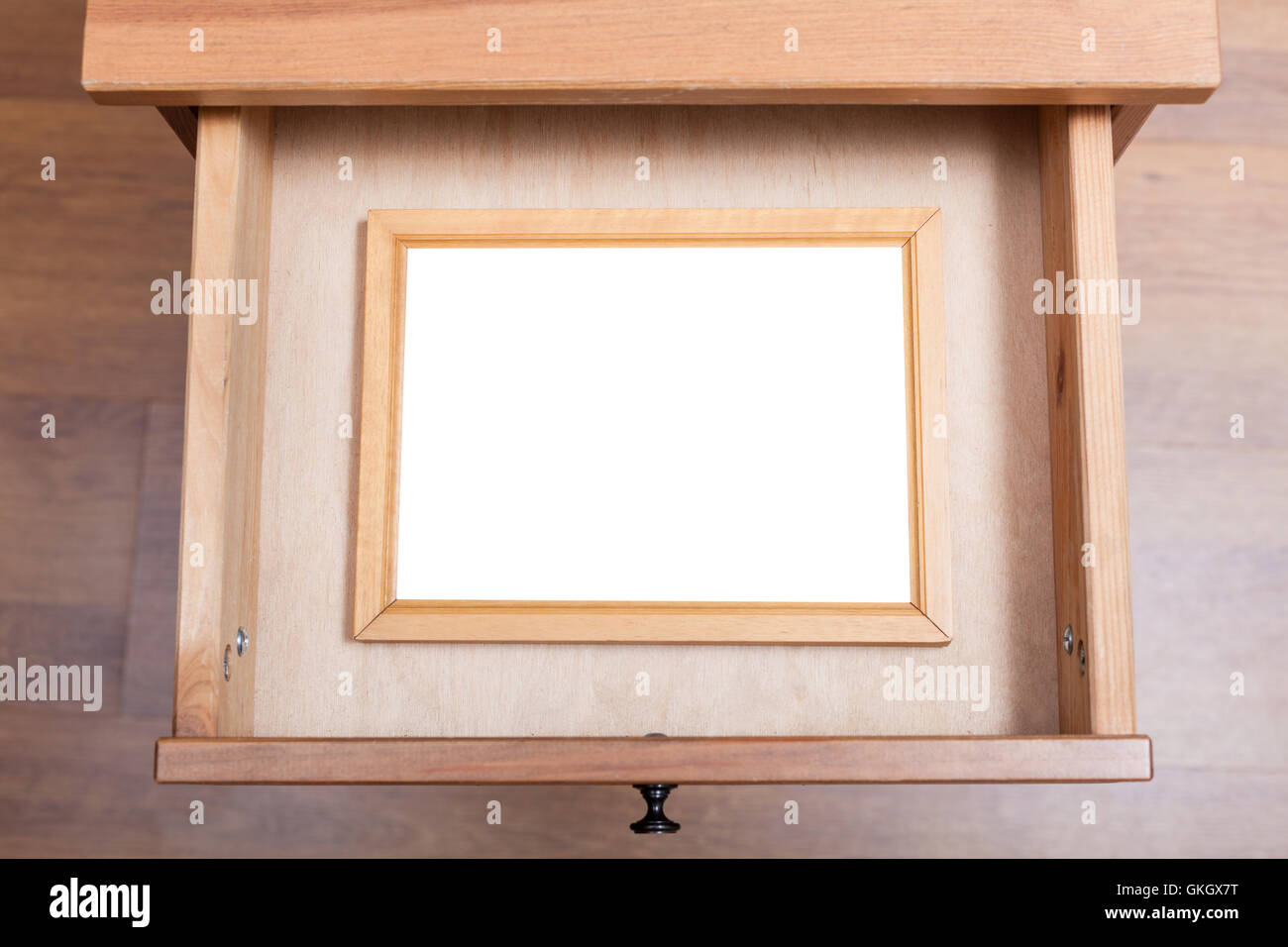 above view of wooden picture frame with cut out canvas in open drawer ...