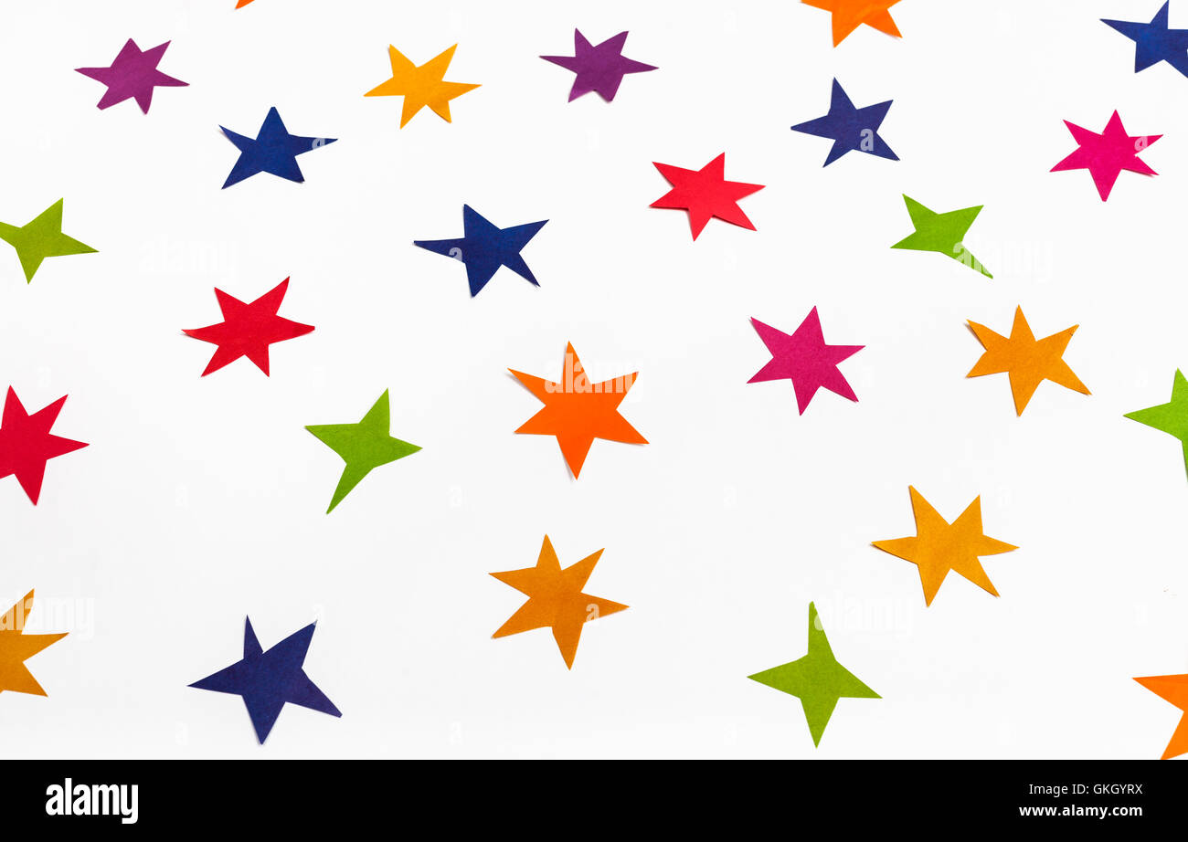 various stars carved by hand from colored paper on white background ...