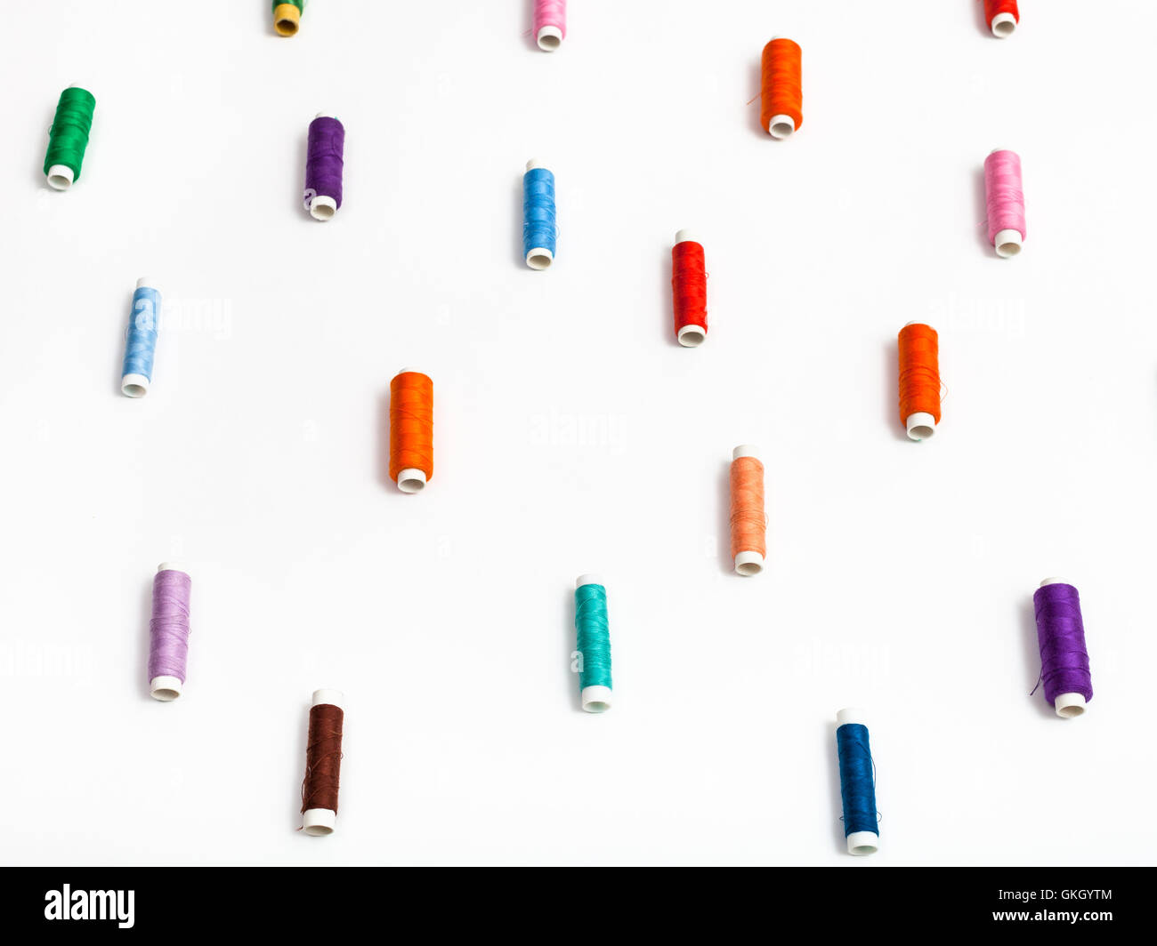 side view of many spools of sewing thread on white background Stock ...