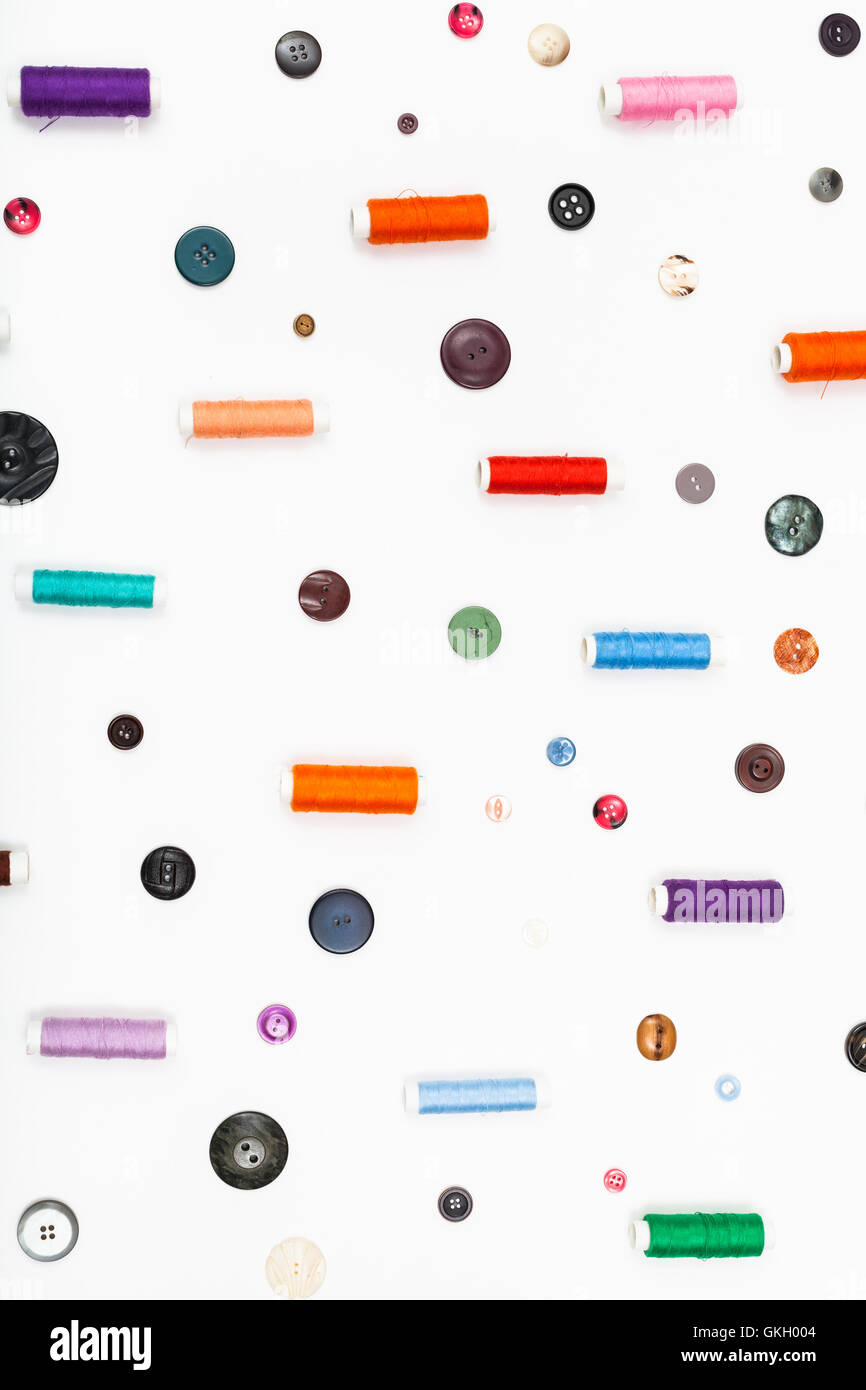 many spools of thread and different buttons on white background Stock ...