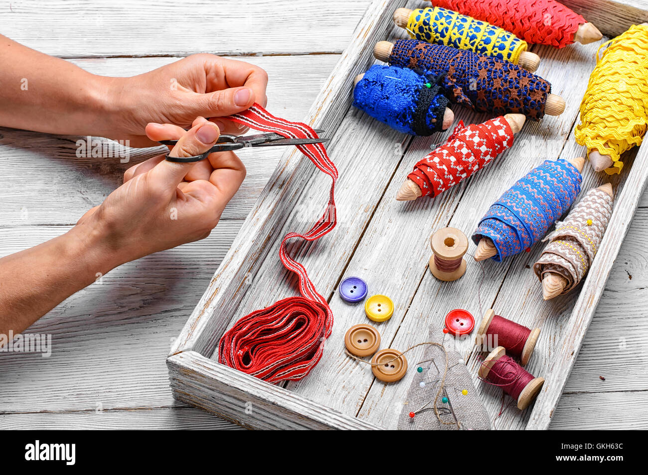 hands of tailor sewing accessories on background thread and buttons ...