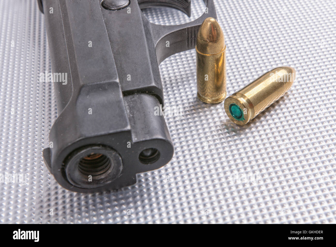 Gold bullets and gun on aluminium background Stock Photo - Alamy