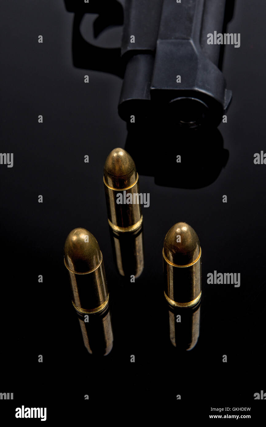 Gold bullets and gun on black background Stock Photo - Alamy