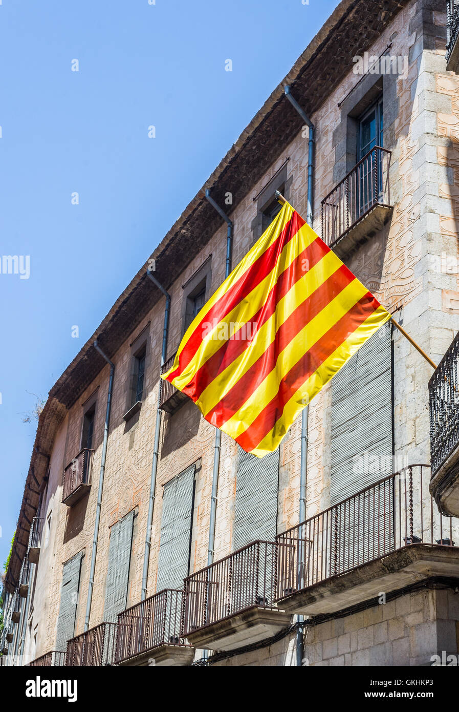 Flag of Catalonia, called Senyera (official), waving in a street of the ...