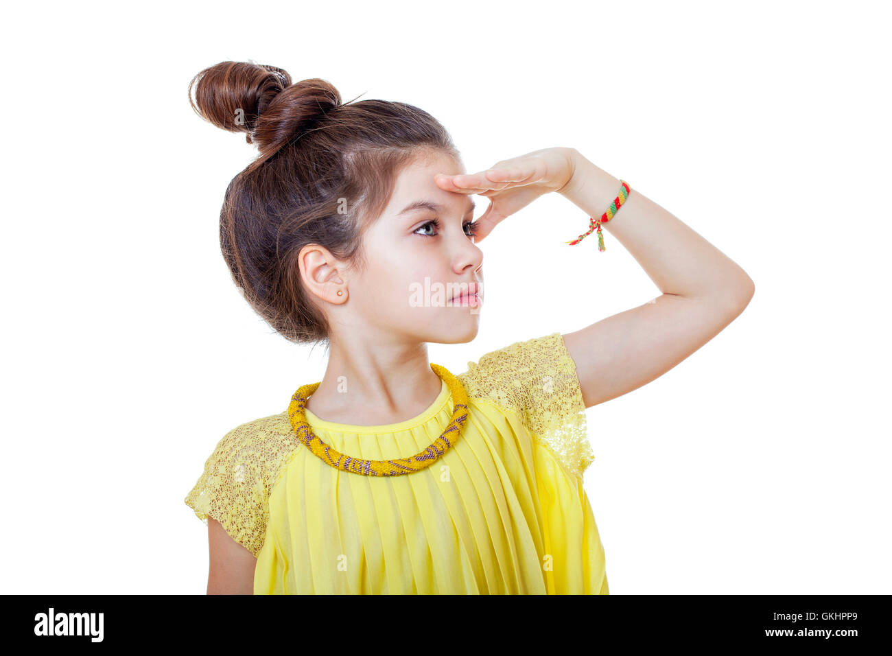 Teenager holding his hand as a visor and looks into the distance ...