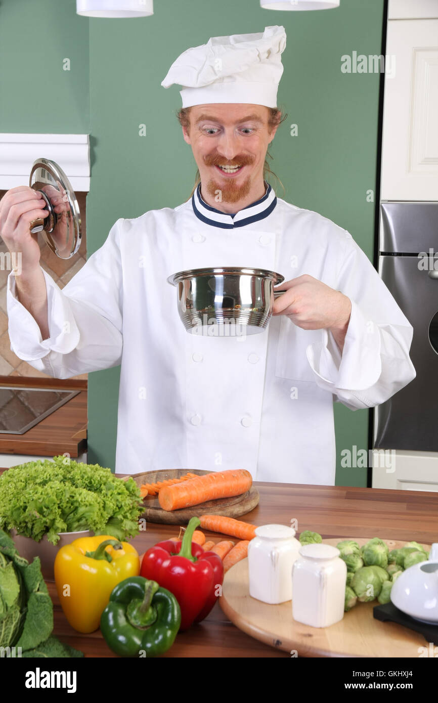 Funny young chef strange looking at pot Stock Photo - Alamy