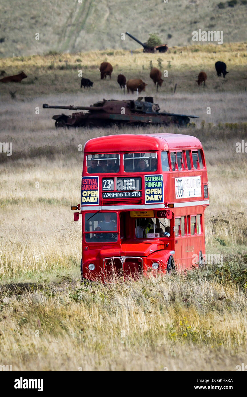 A Routemaster bus passes a destroyed tank as it makes its way from the ...