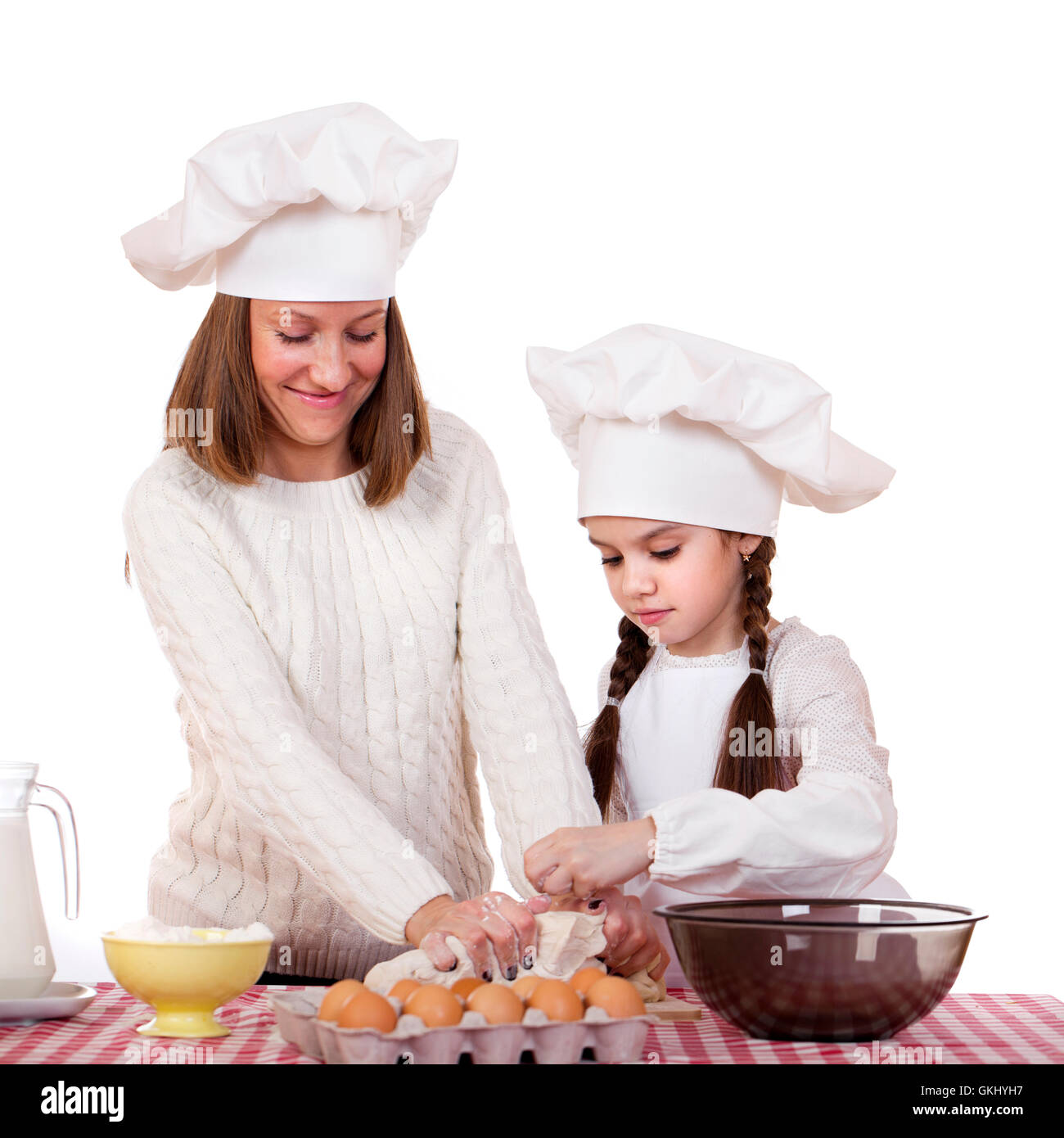 Caucasian mother and daughter preparing dough and having fun, isolated ...