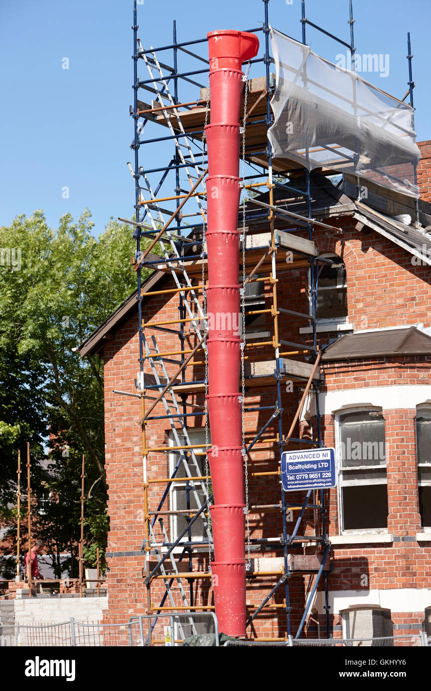 plastic rubbish chute attached to scaffolding on house extension in ...