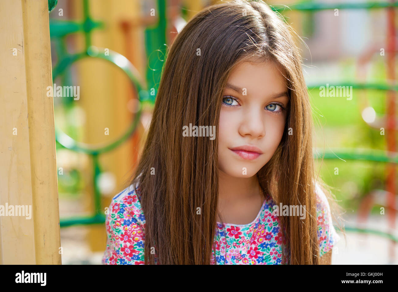 Cose up, Beautiful little girl on green background of summer city park ...
