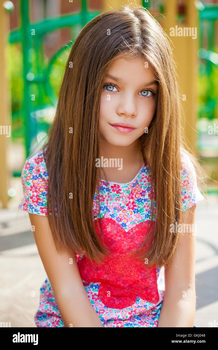 Cose up, Beautiful little girl on green background of summer city park ...