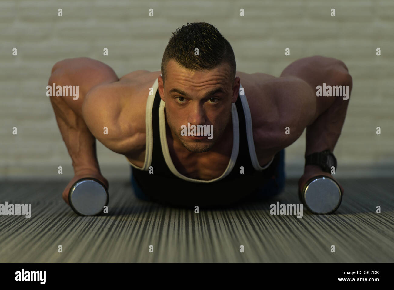 Young Bodybuilder Doing Pushups With Dumbbells As Part Of Bodybuilding ...