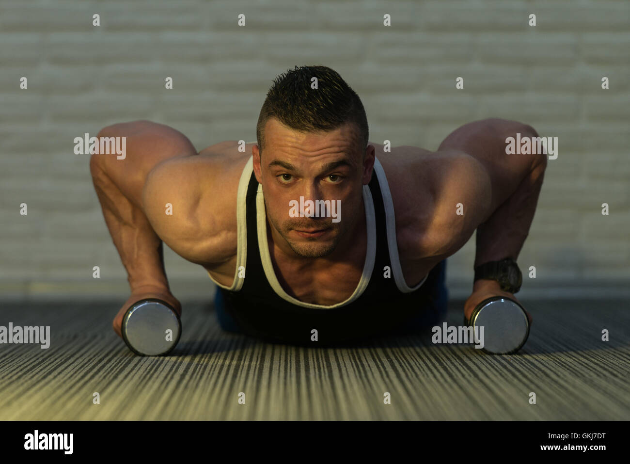 Young Man Doing Pushups With Dumbbells As Part Of Bodybuilding Training ...