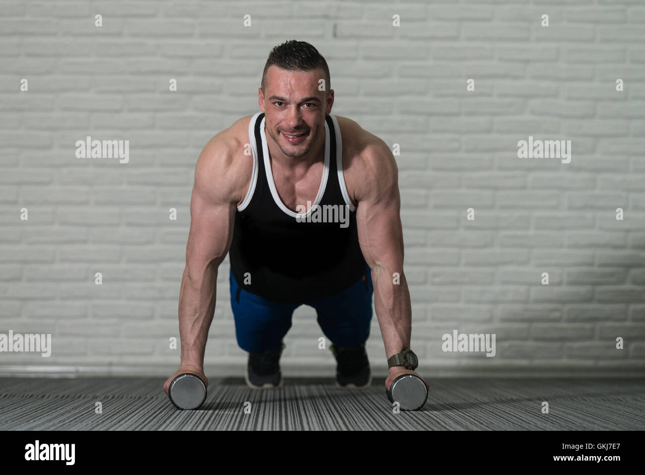Young Bodybuilder Doing Pushups With Dumbbells As Part Of Bodybuilding ...