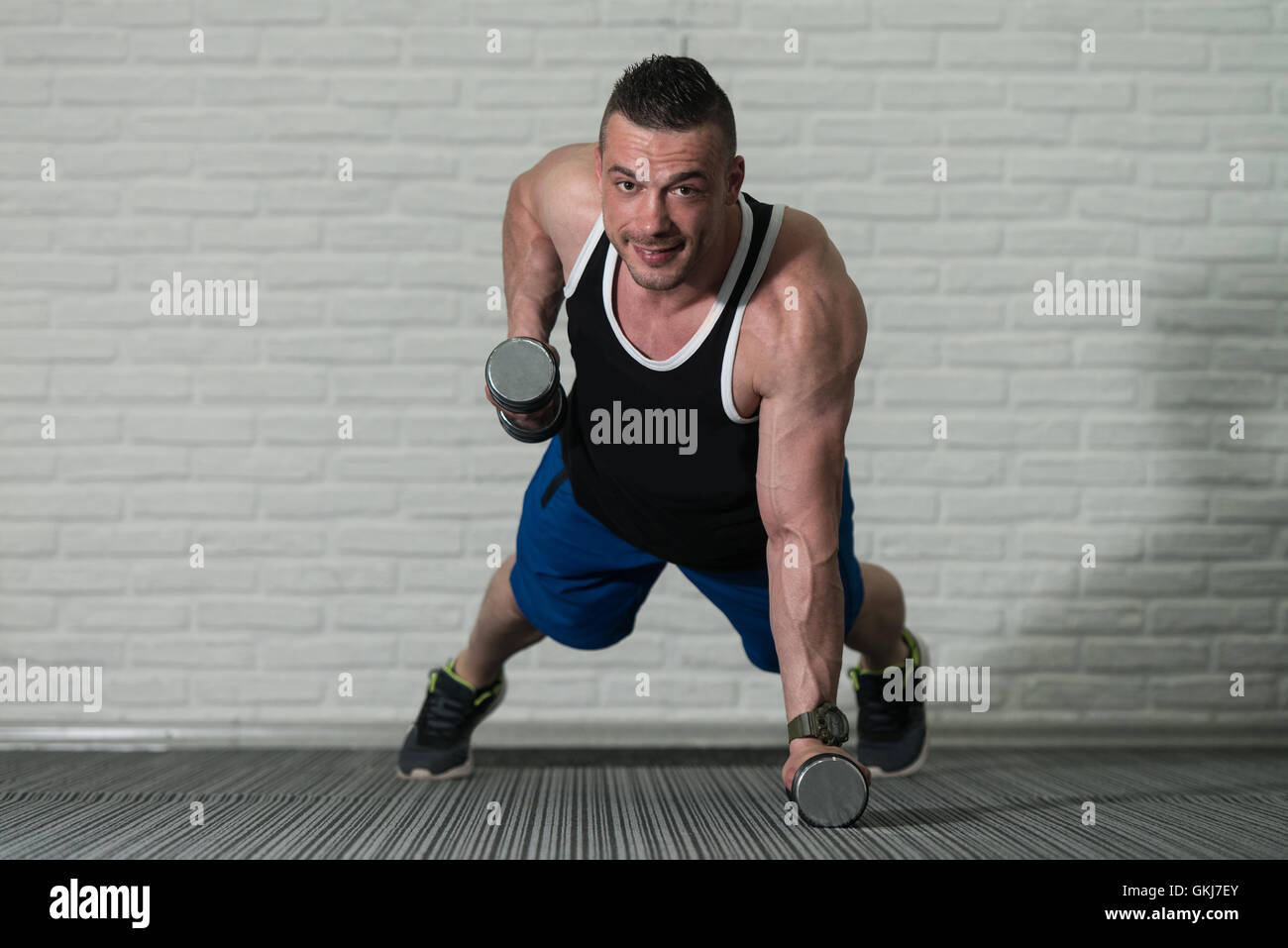 Young Bodybuilder Doing Pushups With Dumbbells As Part Of Bodybuilding ...