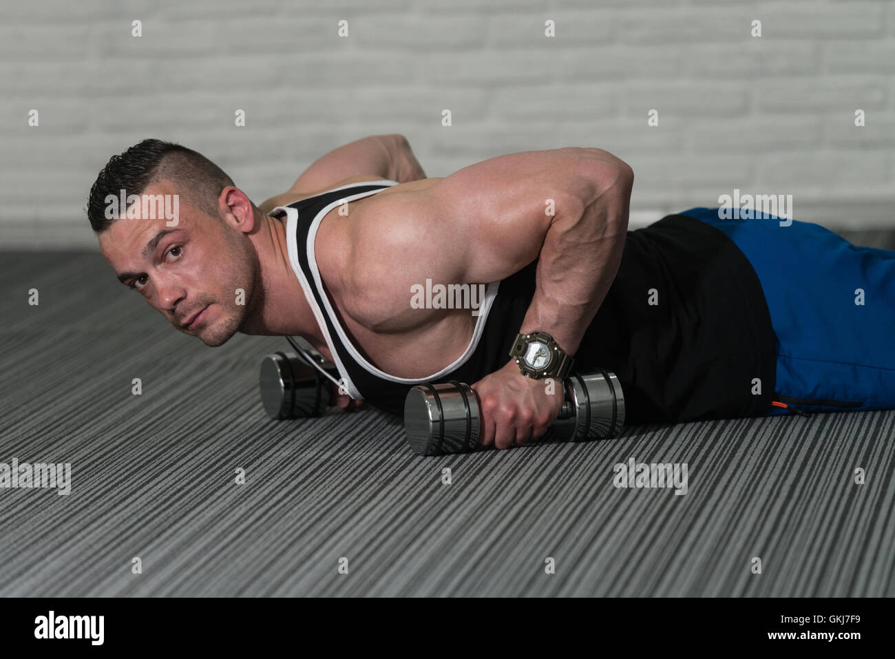 Young Bodybuilder Doing Pushups With Dumbbells As Part Of Bodybuilding ...