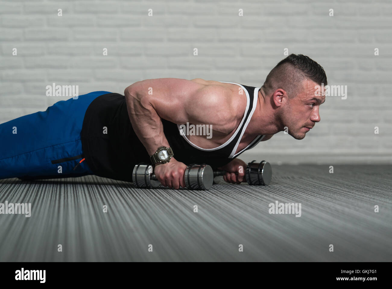 Young Man Doing Pushups With Dumbbells As Part Of Bodybuilding Training ...