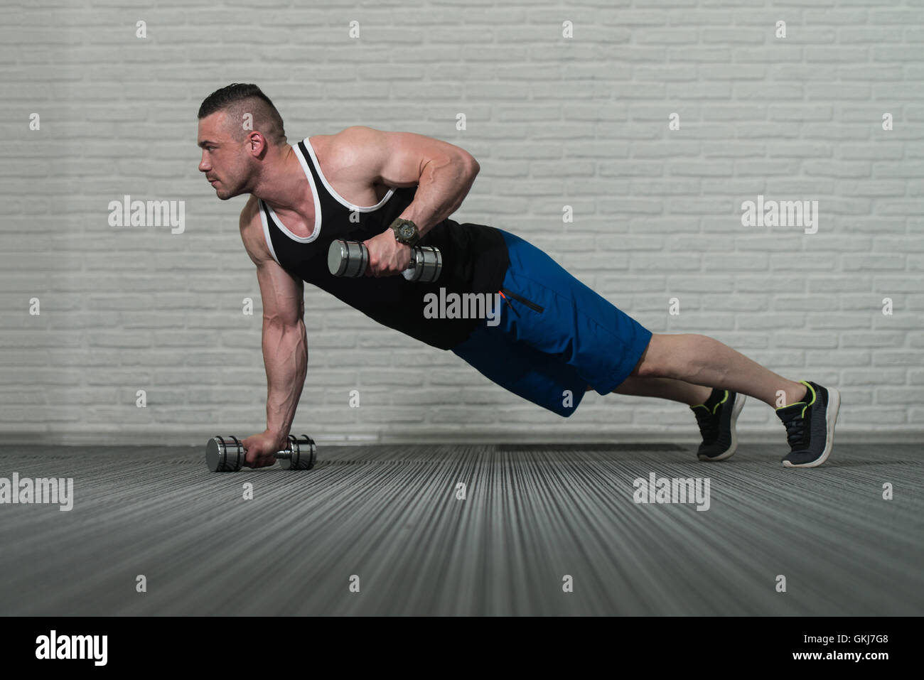 Young Bodybuilder Doing Pushups With Dumbbells As Part Of Bodybuilding ...