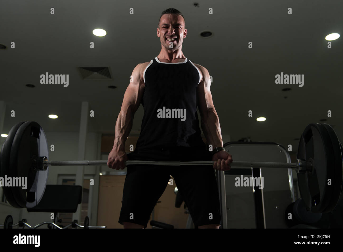 Muscular Man Doing Heavy Weight Exercise For Back With Barbell In ...