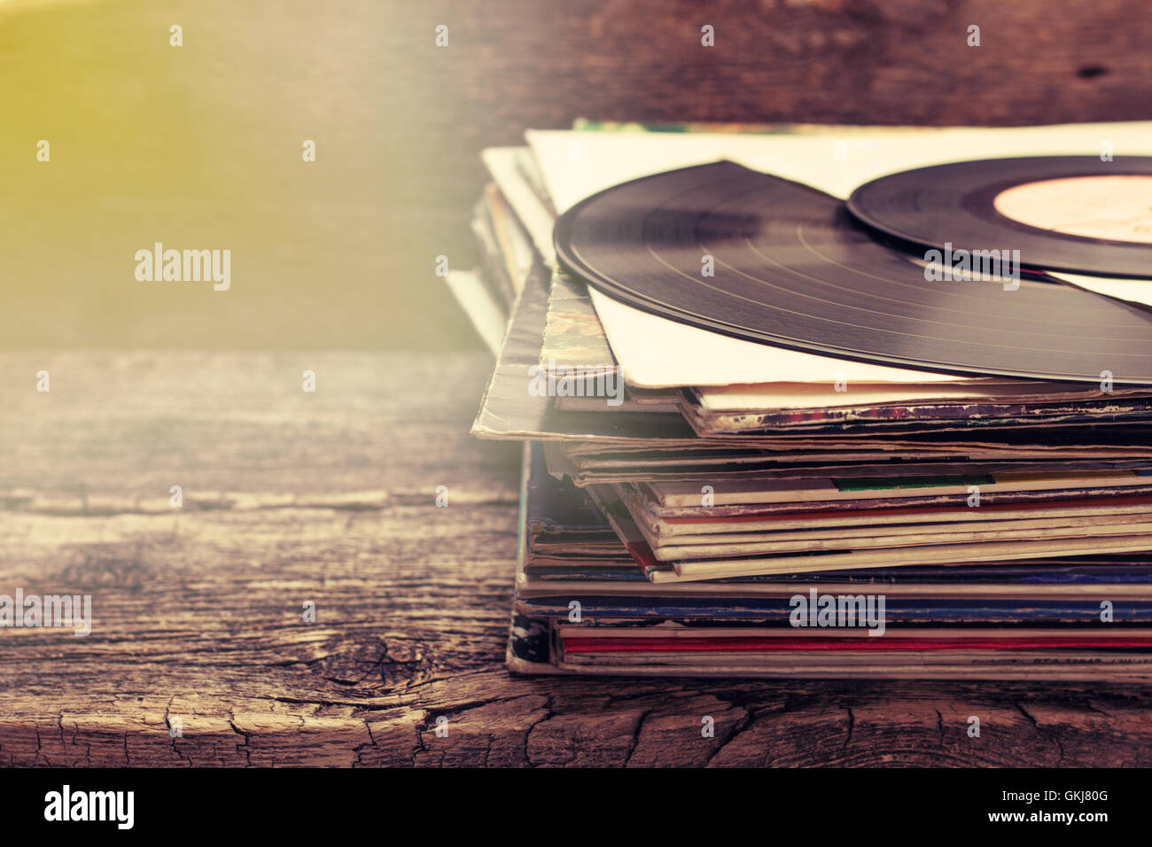 stack of old records on the old wooden background in vintage style ...