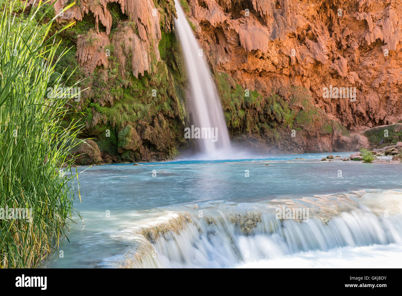 A travertine ledge below Havasu Falls where it plunges into a deep blue ...