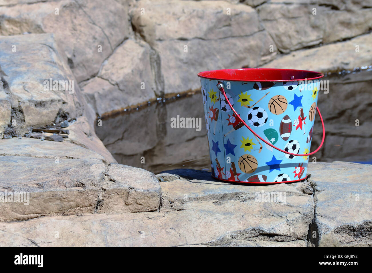 Bucket on the Rock Wall Stock Photo - Alamy