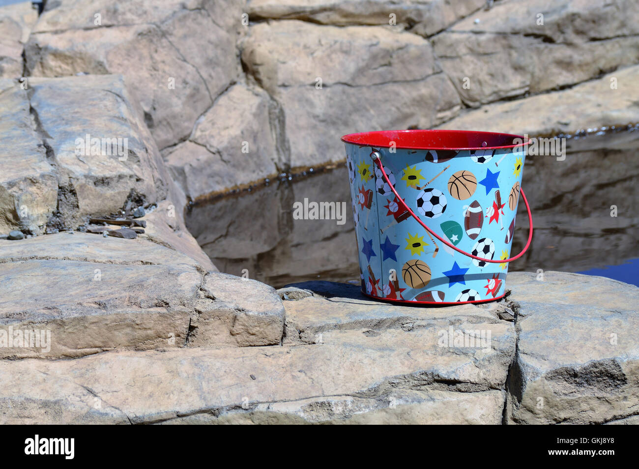 Bucket on the Rock Wall Stock Photo - Alamy