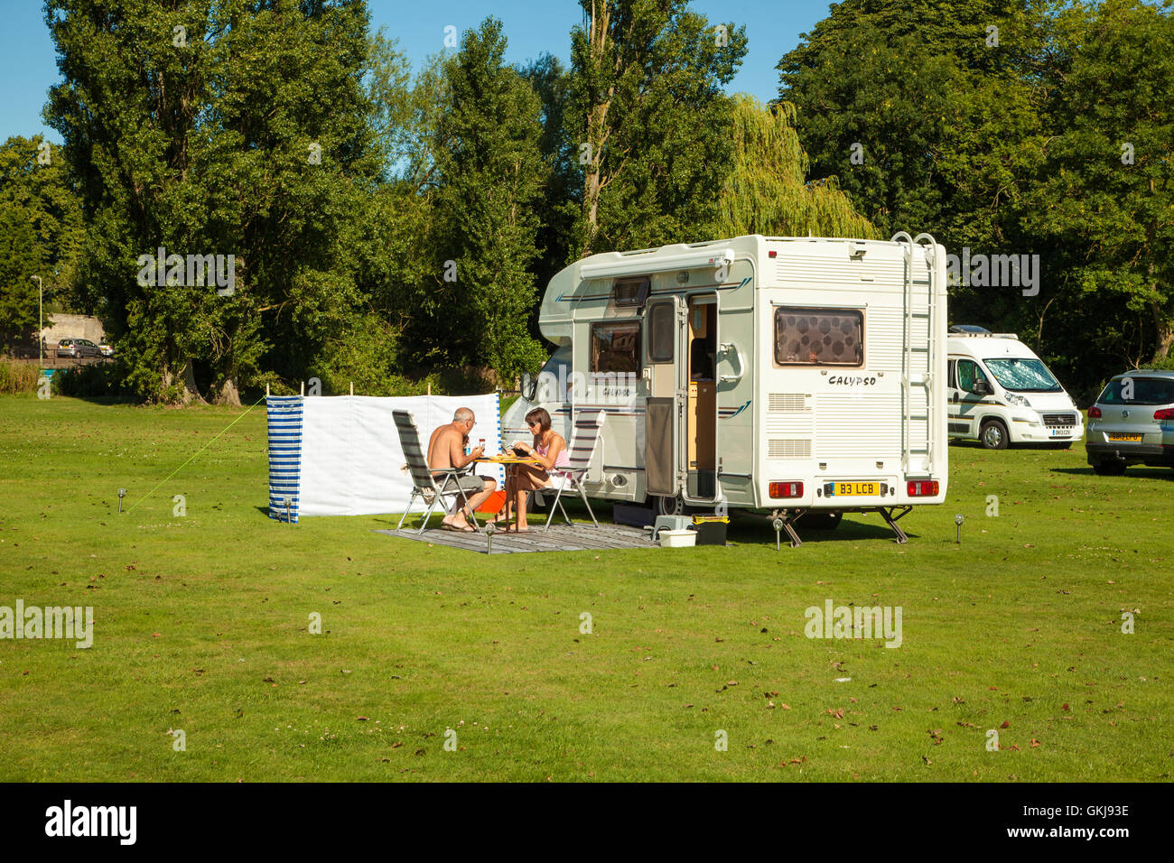 Man and woman enjoying a meal outside thier motor home at a caravan ...