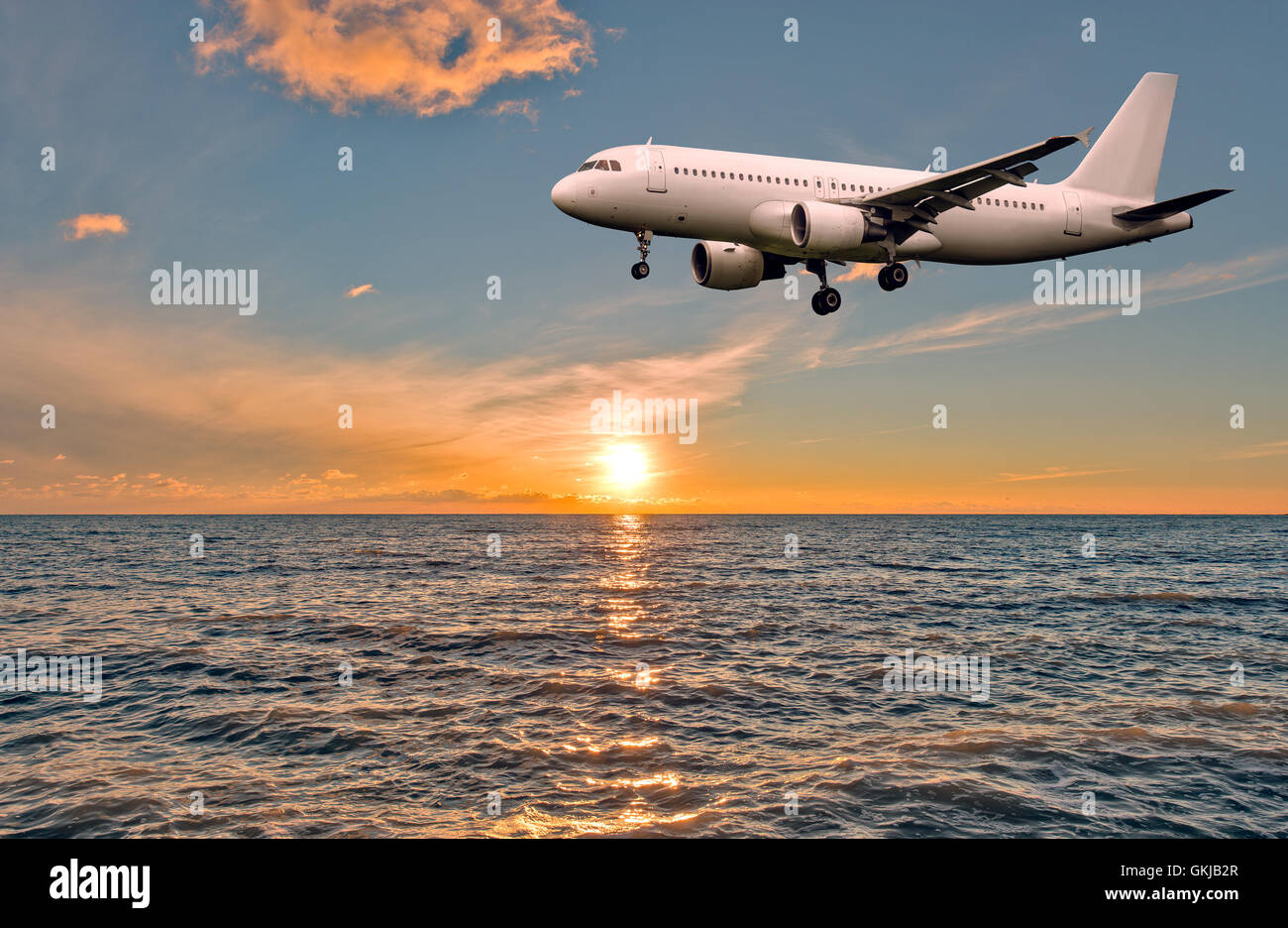 Flight of the plane above the ocean before landing at sunset Stock ...