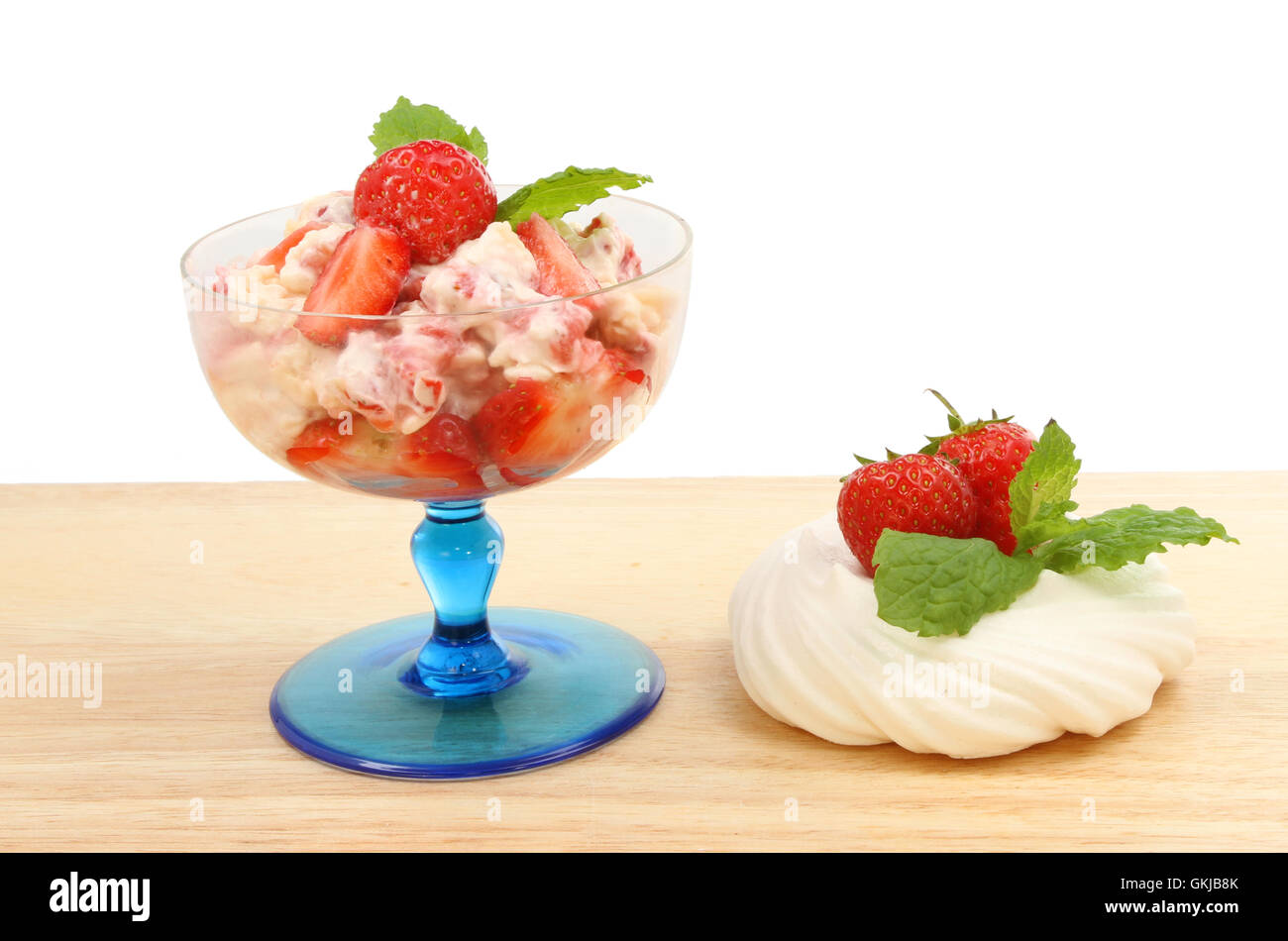 Eton mess in a sundae glass with strawberries and a meringue nest on a ...