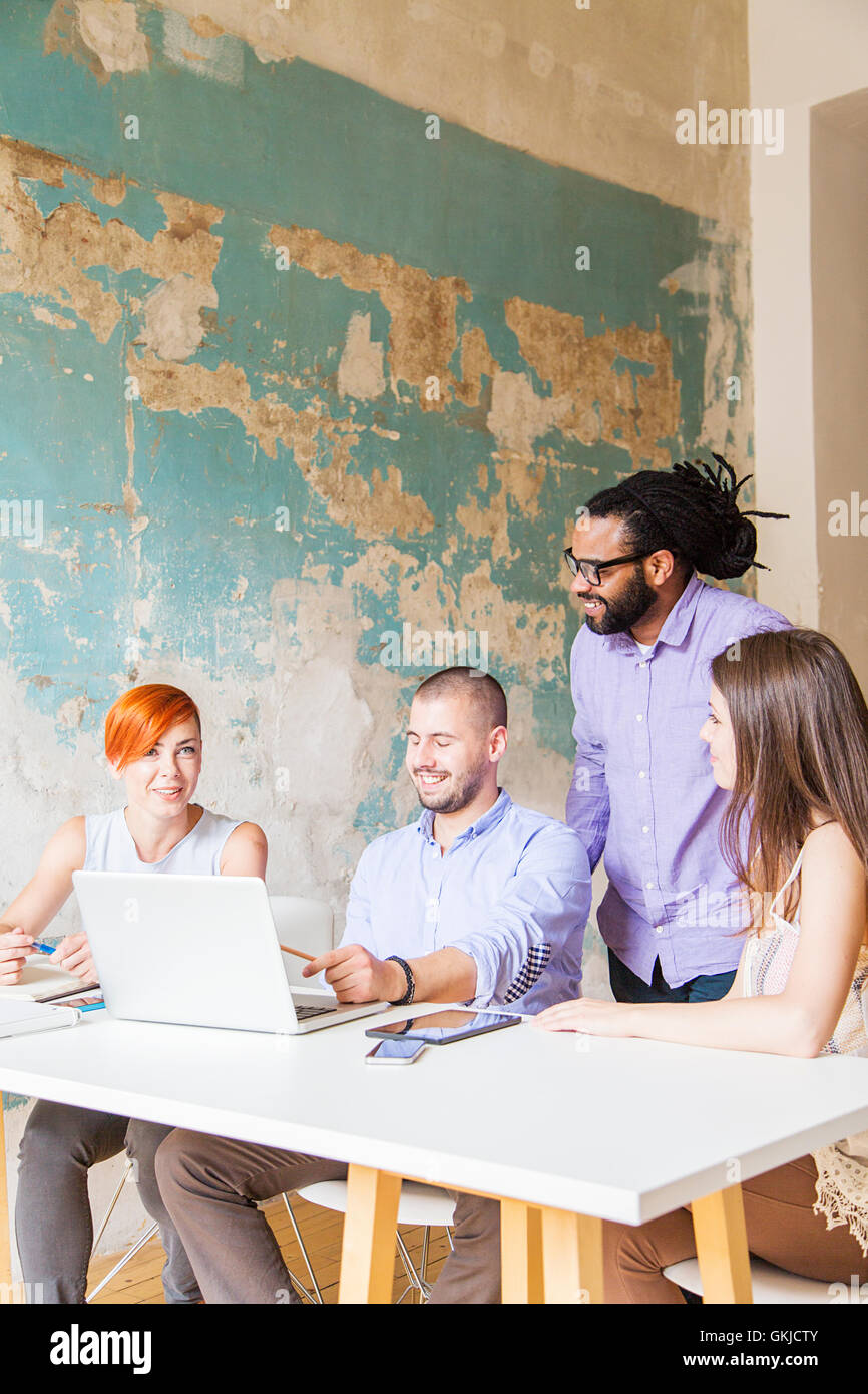 Young people working by the desk in the grunge office Stock Photo - Alamy
