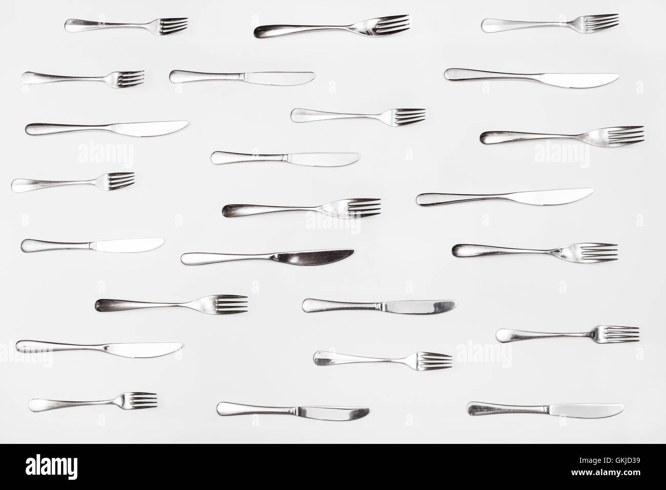 top view of table knives and forks arranged on white background Stock ...