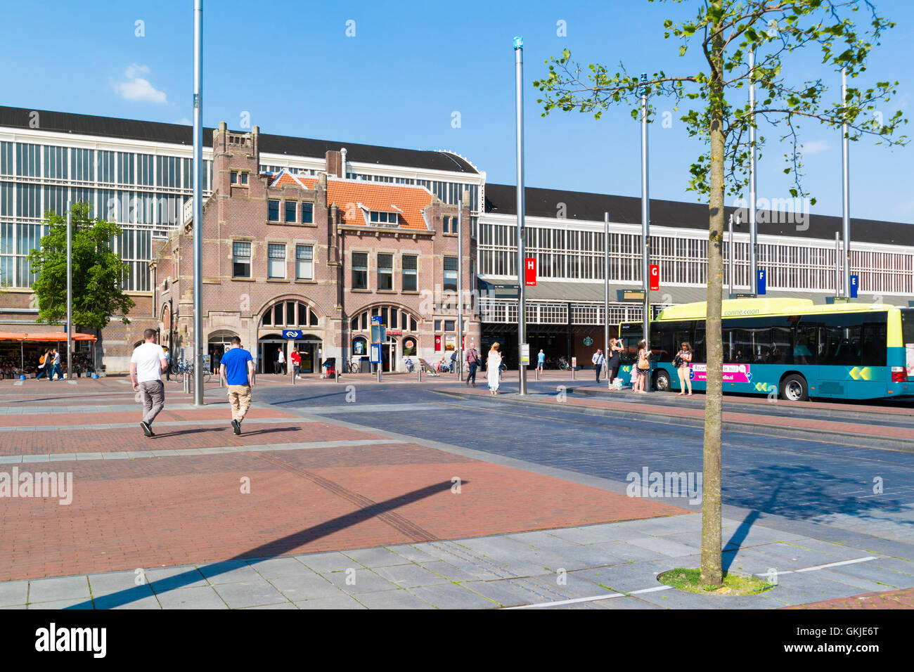 People, bus and station building on Stationsplein square in city of ...