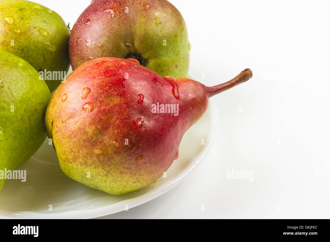 colorful pears in the dish on a white background Stock Photo - Alamy