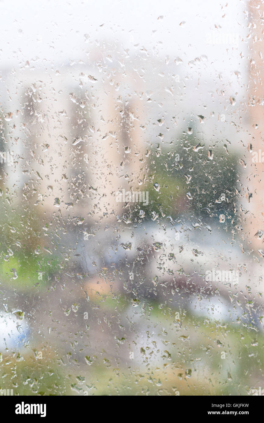 rainy weather in city - view of wet window glass of apartment house ...