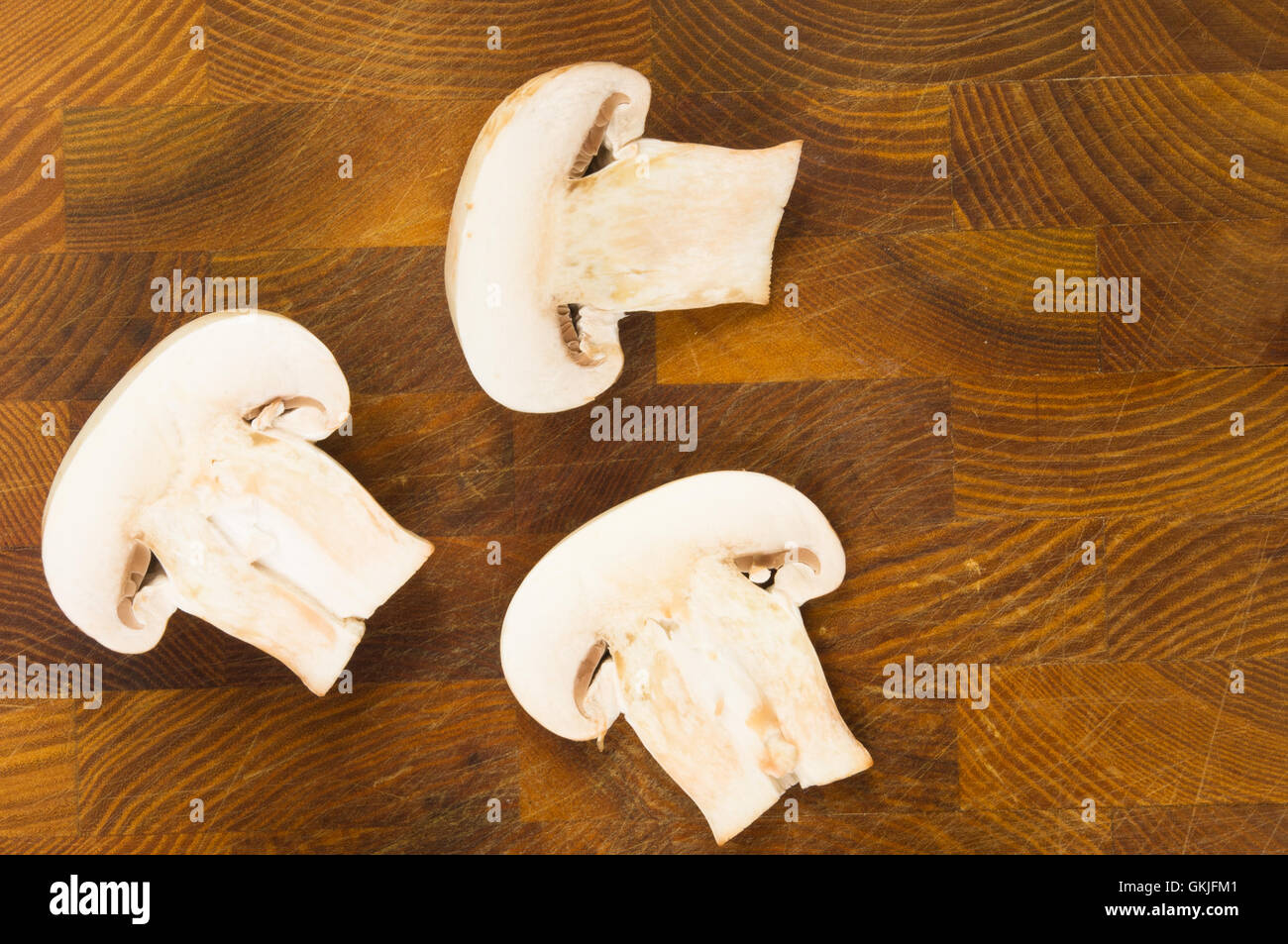 whole and cut scattered mushrooms champignons on wooden background ...