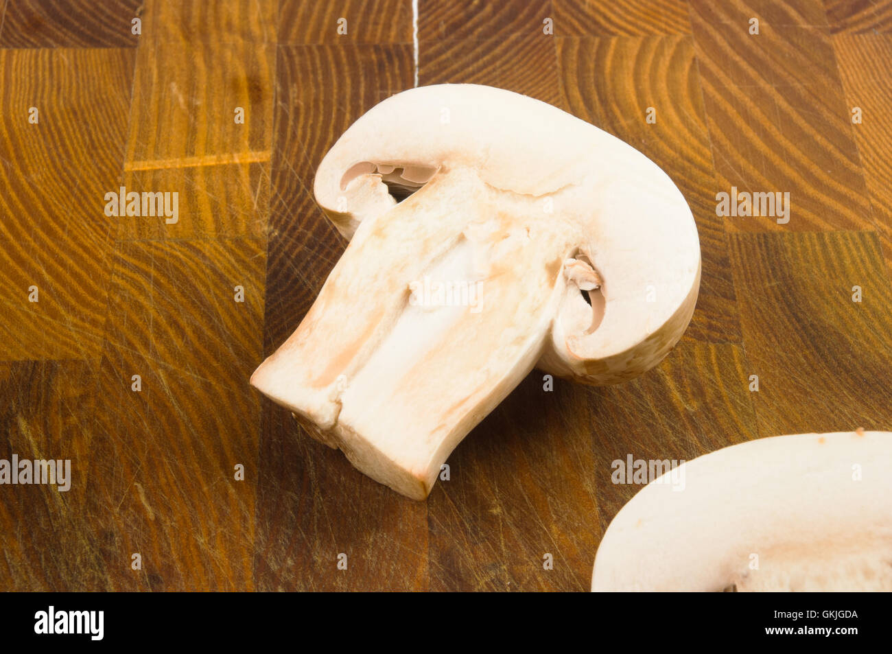 whole and cut scattered mushrooms champignons on wooden background ...