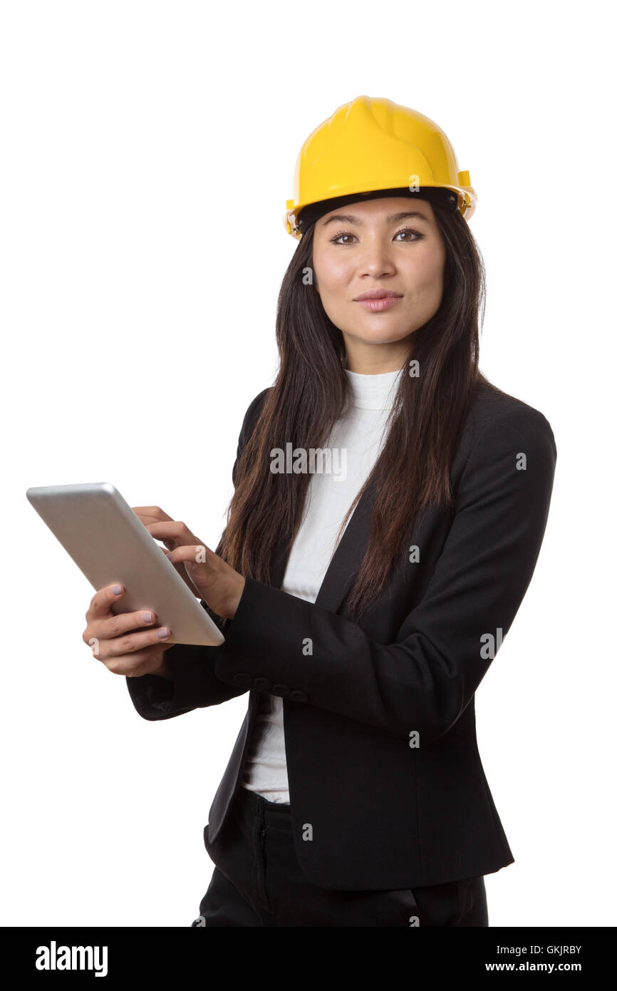 business woman wearing a hard hat looking at a plan on a tablet ...