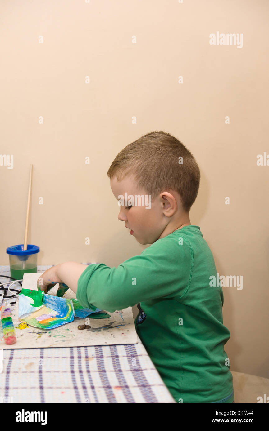 boy at the table that a master from the paper Stock Photo - Alamy