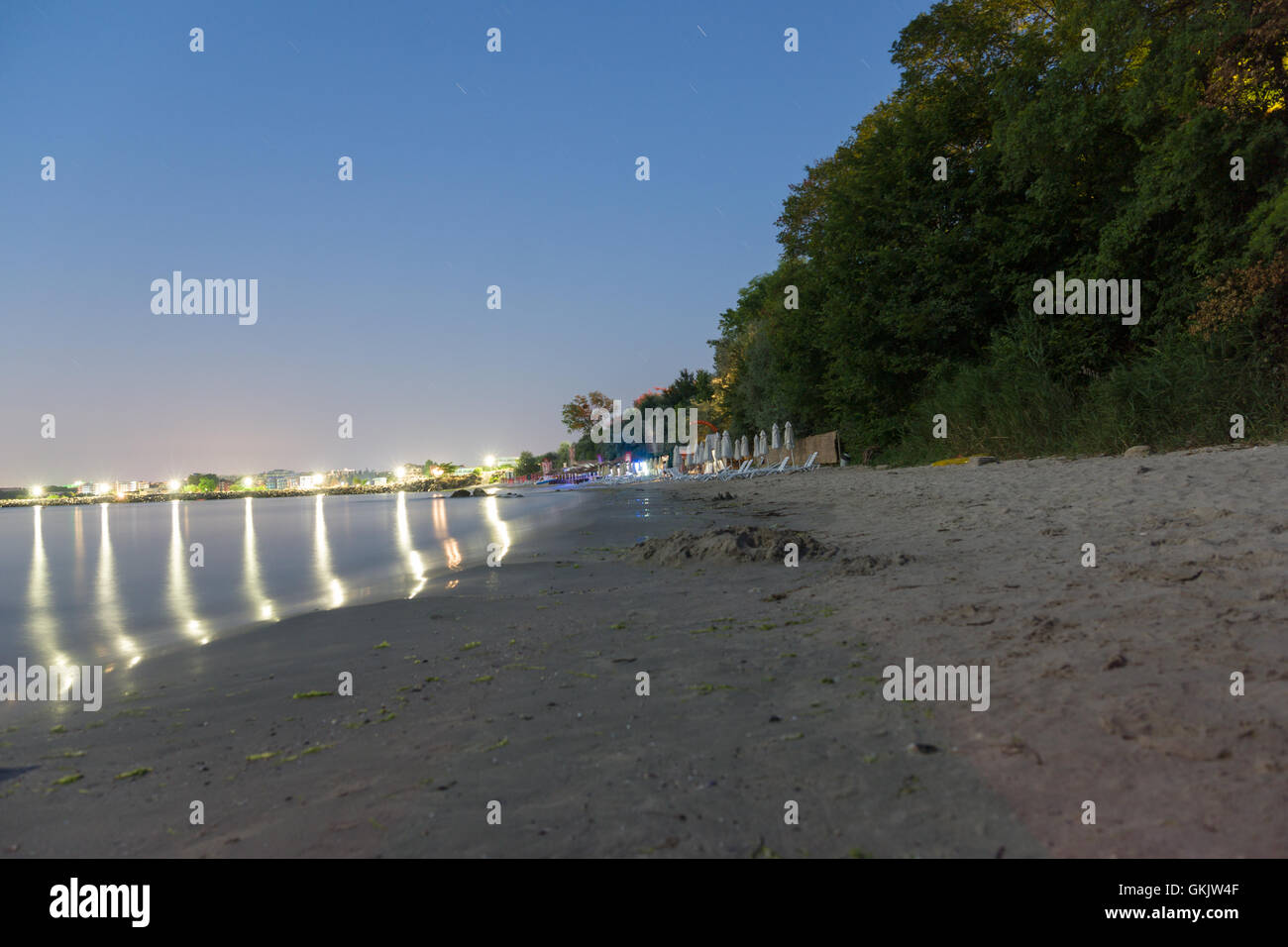 Night beach with folded umbrellas and sunbeds Stock Photo - Alamy