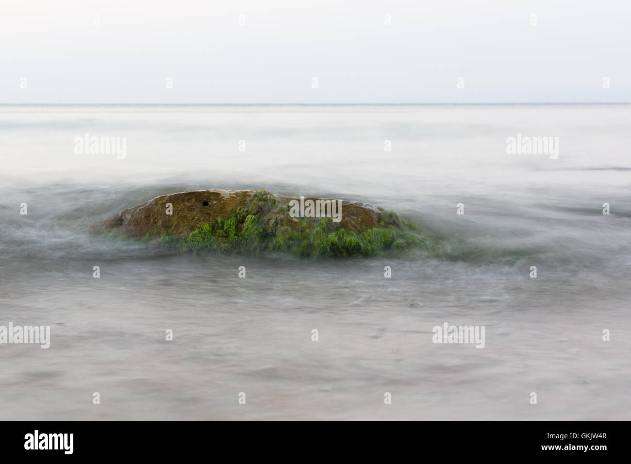 stones on the beach under the incoming wave Stock Photo - Alamy