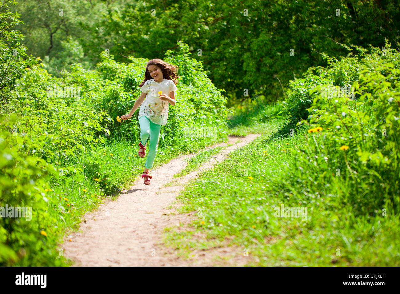Happy little girl running in summer park Stock Photo - Alamy