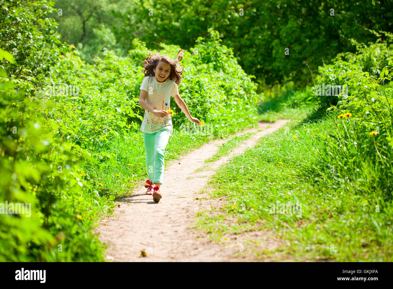 Happy little girl running in summer park Stock Photo - Alamy