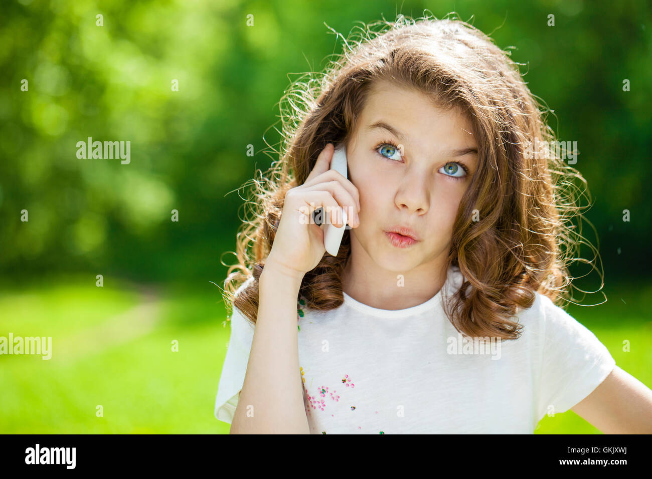 Beautiful little girl calling by mobile phone on the background of ...