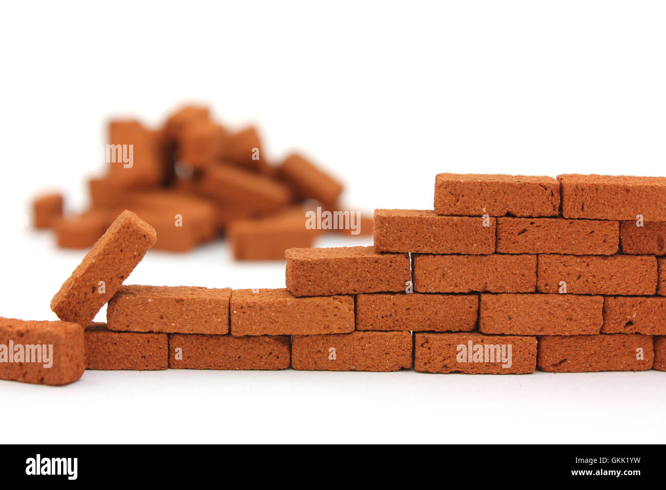 Building a brick wall with a white background Stock Photo - Alamy